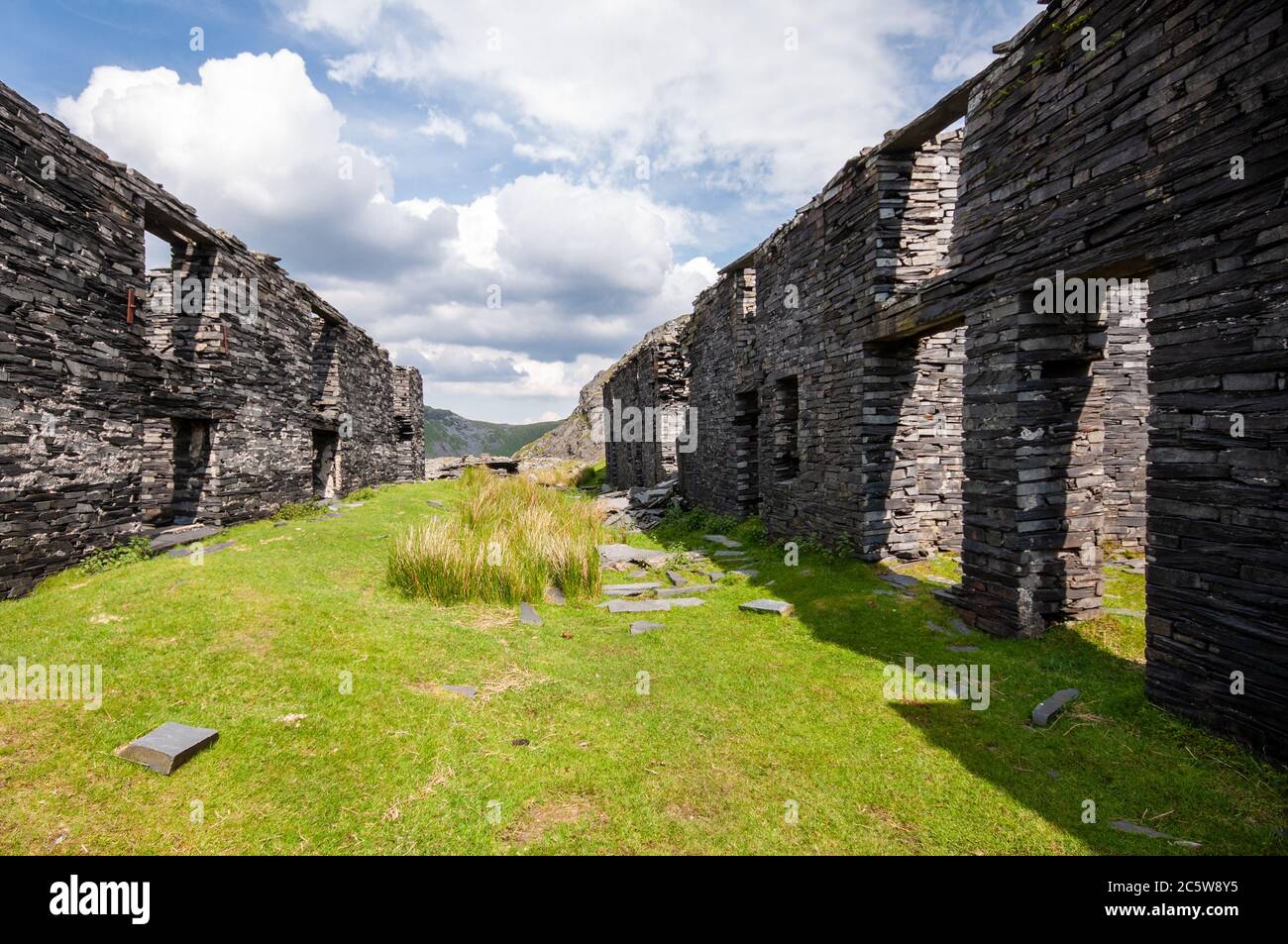 Abandoned and derelict slate mining buildings stand amidst scree tips ...