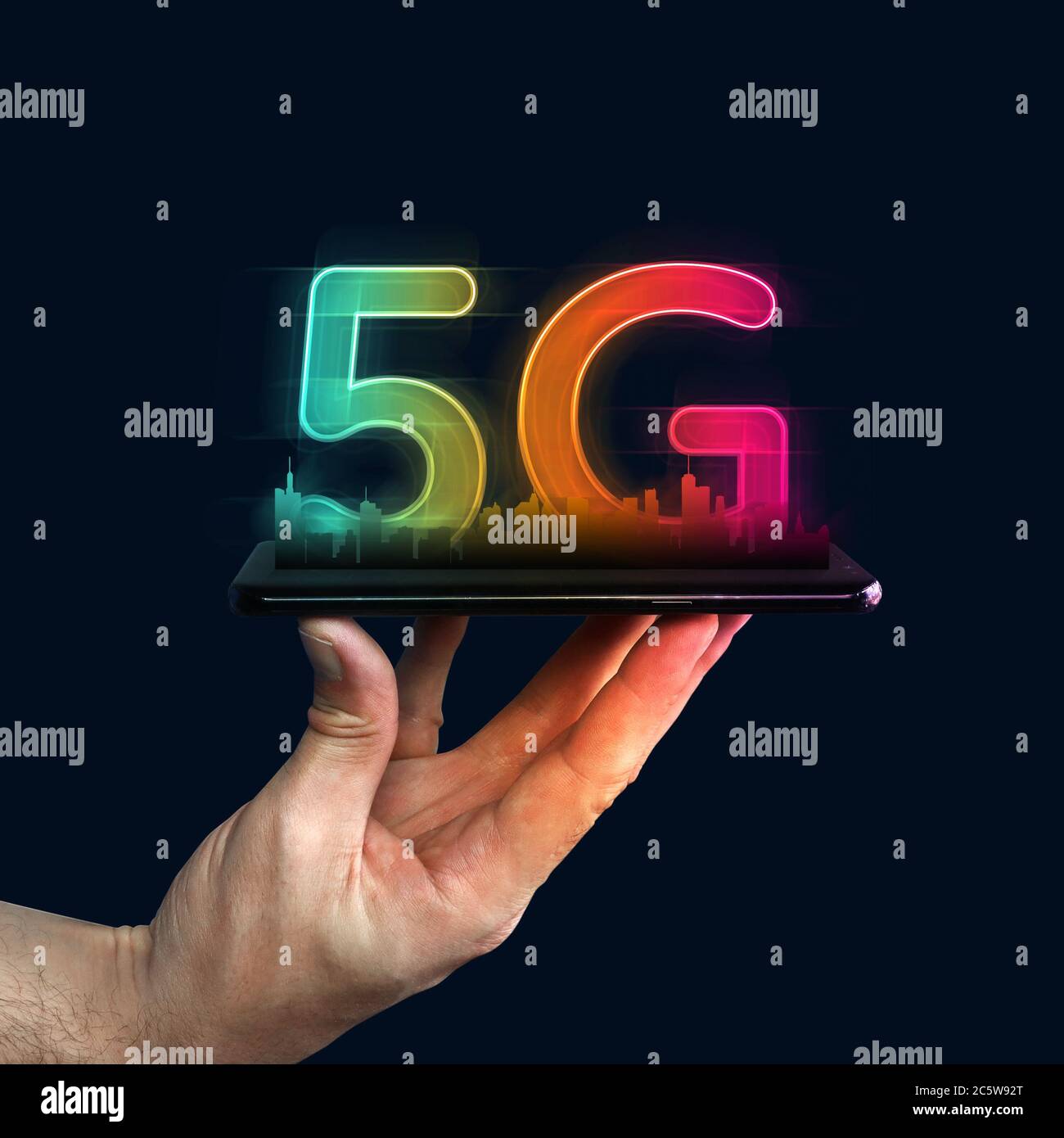 5G Standard. Hand holds cell phone with colorful logotye on it. Skyline ...