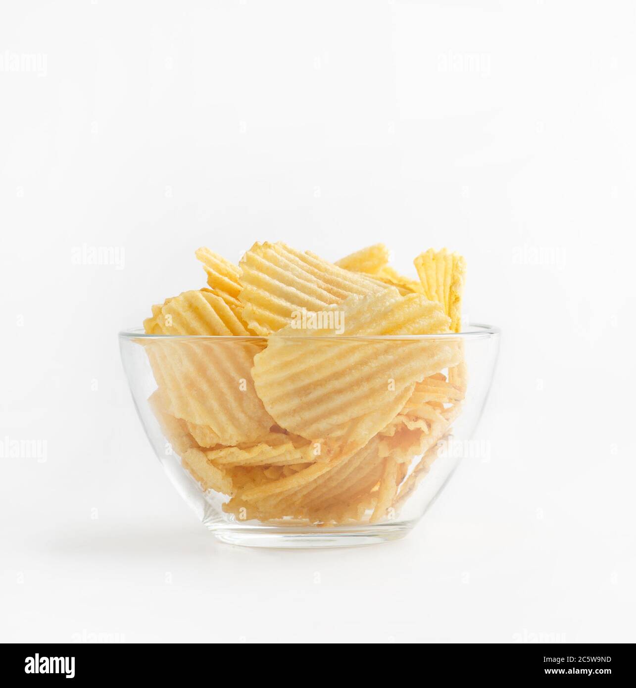 Ribbed chips in glass plate isolated on white background Stock Photo ...