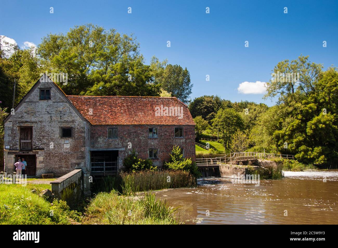 The River Stour tumbles over a weir beside the traditional old flour ...