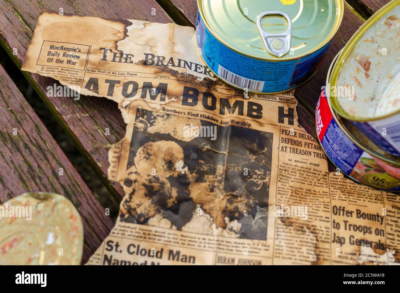 Torn newspaper and tin cans lying on the old newspaper illustrating the ...