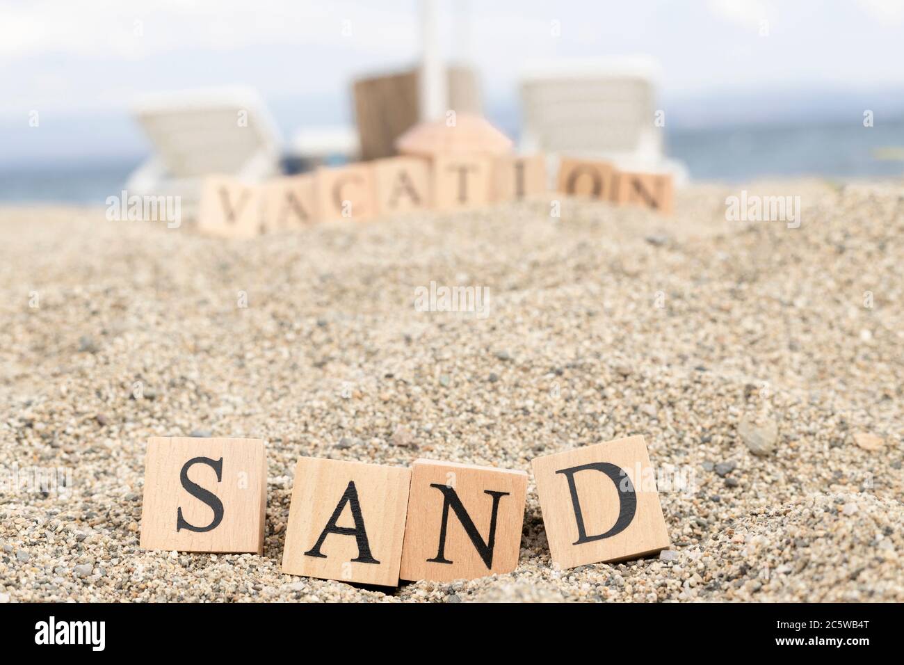 The word sand from wooden cubes. Close-up on the beach sand Stock Photo ...