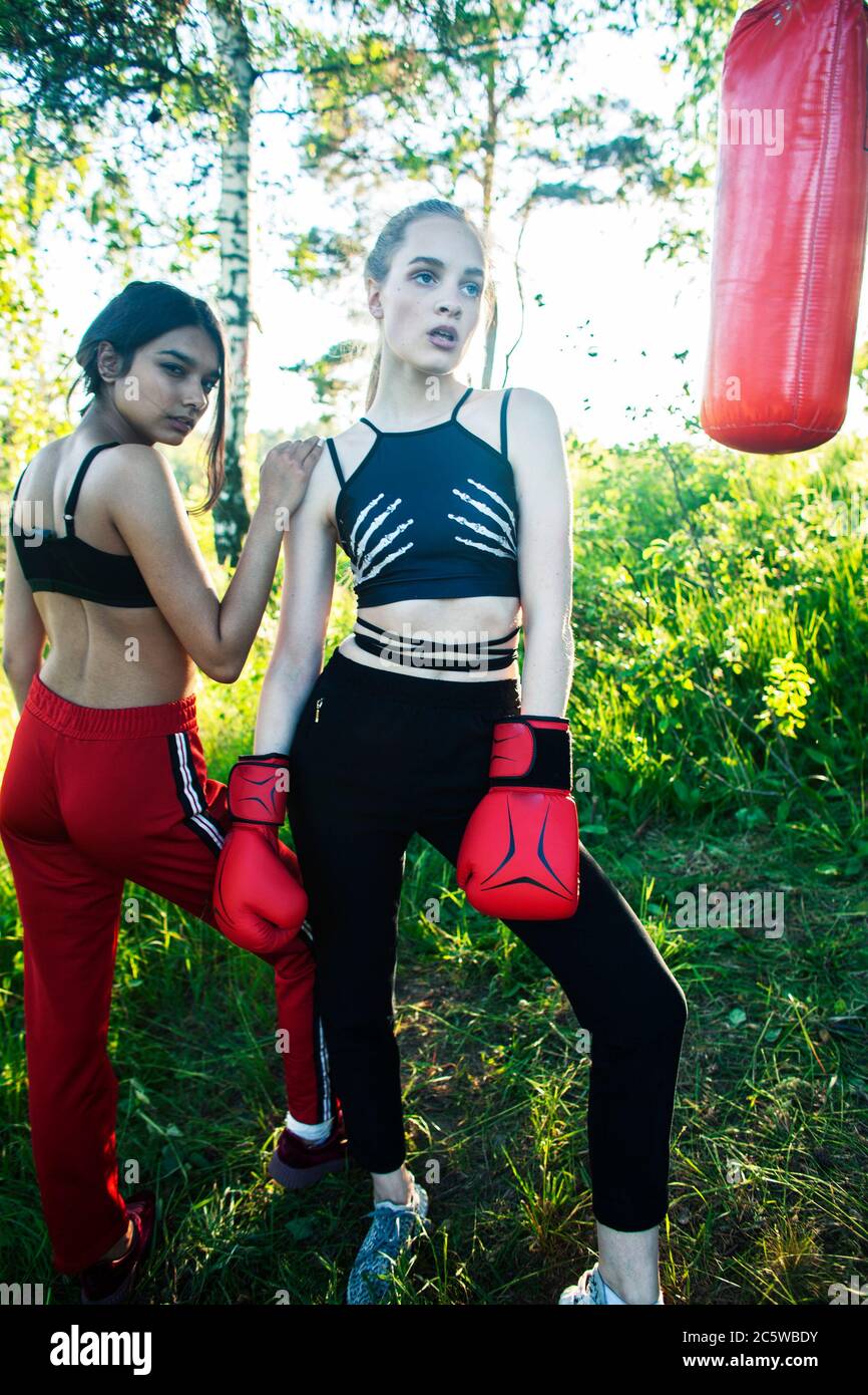 two diverse nations girls fighting boxing outside in green park, sport ...