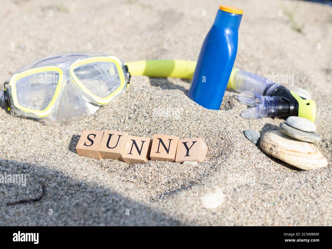 Sunny word made of wooden cubes. Sunglasses and sunscreen and slippers ...
