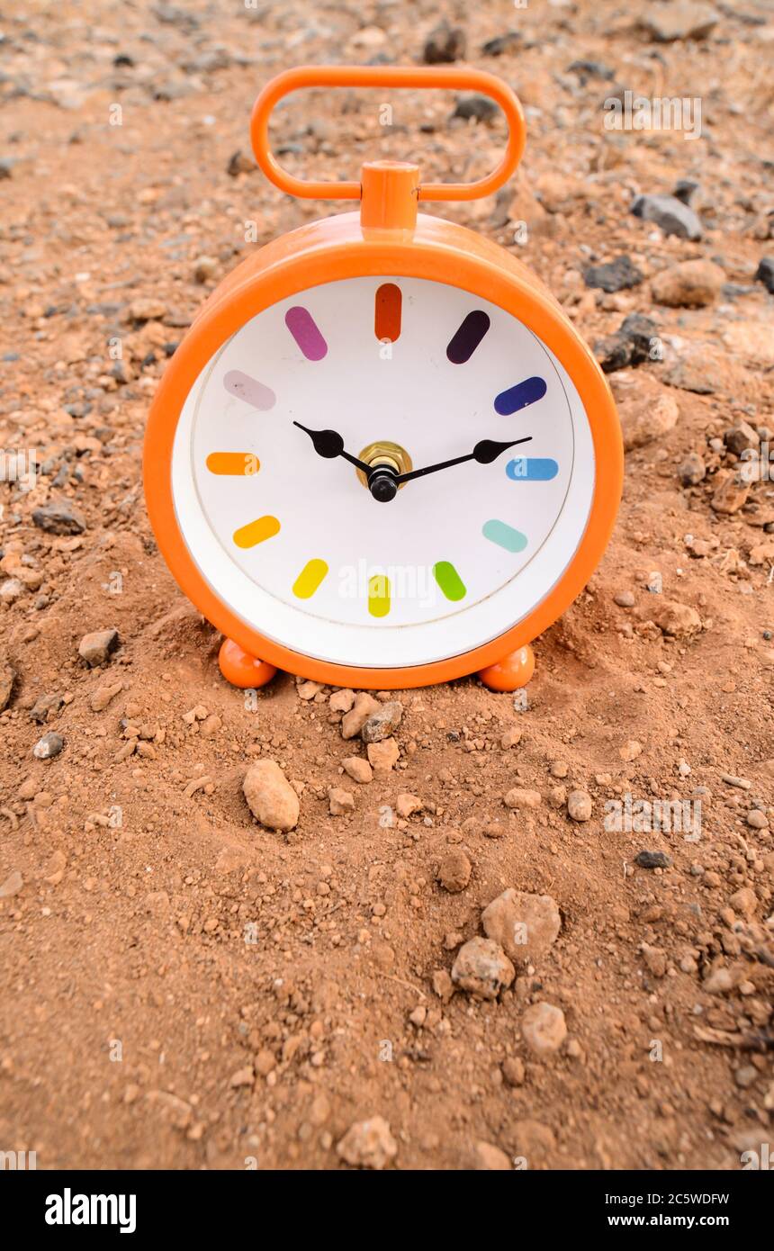 Classic Analog Clock In The Sand On The Rock Desert Stock Photo - Alamy