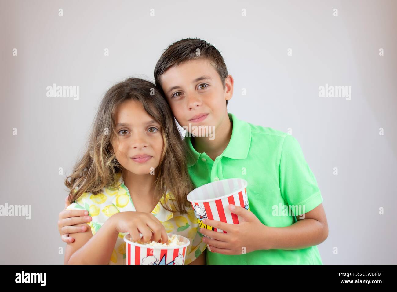 Two friends eating popcorn together Stock Photo - Alamy