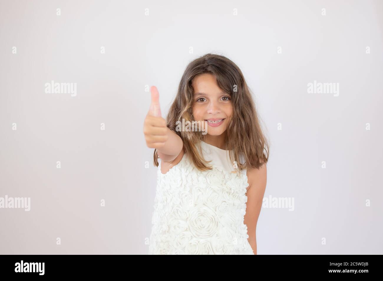 Beautiful little girl making finger up gesture Stock Photo - Alamy