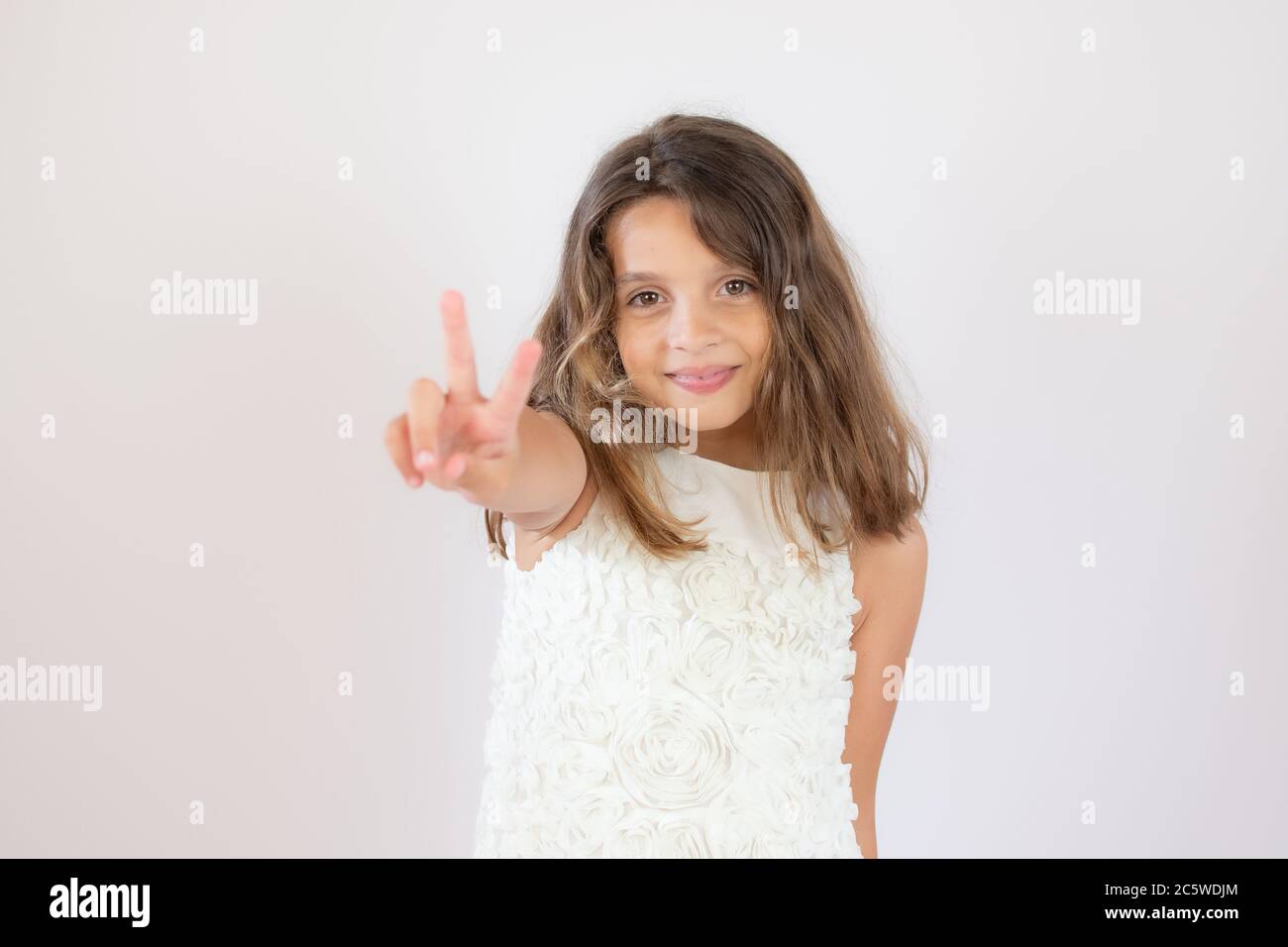 Beautiful little girl making victory gesture with her fingers Stock ...