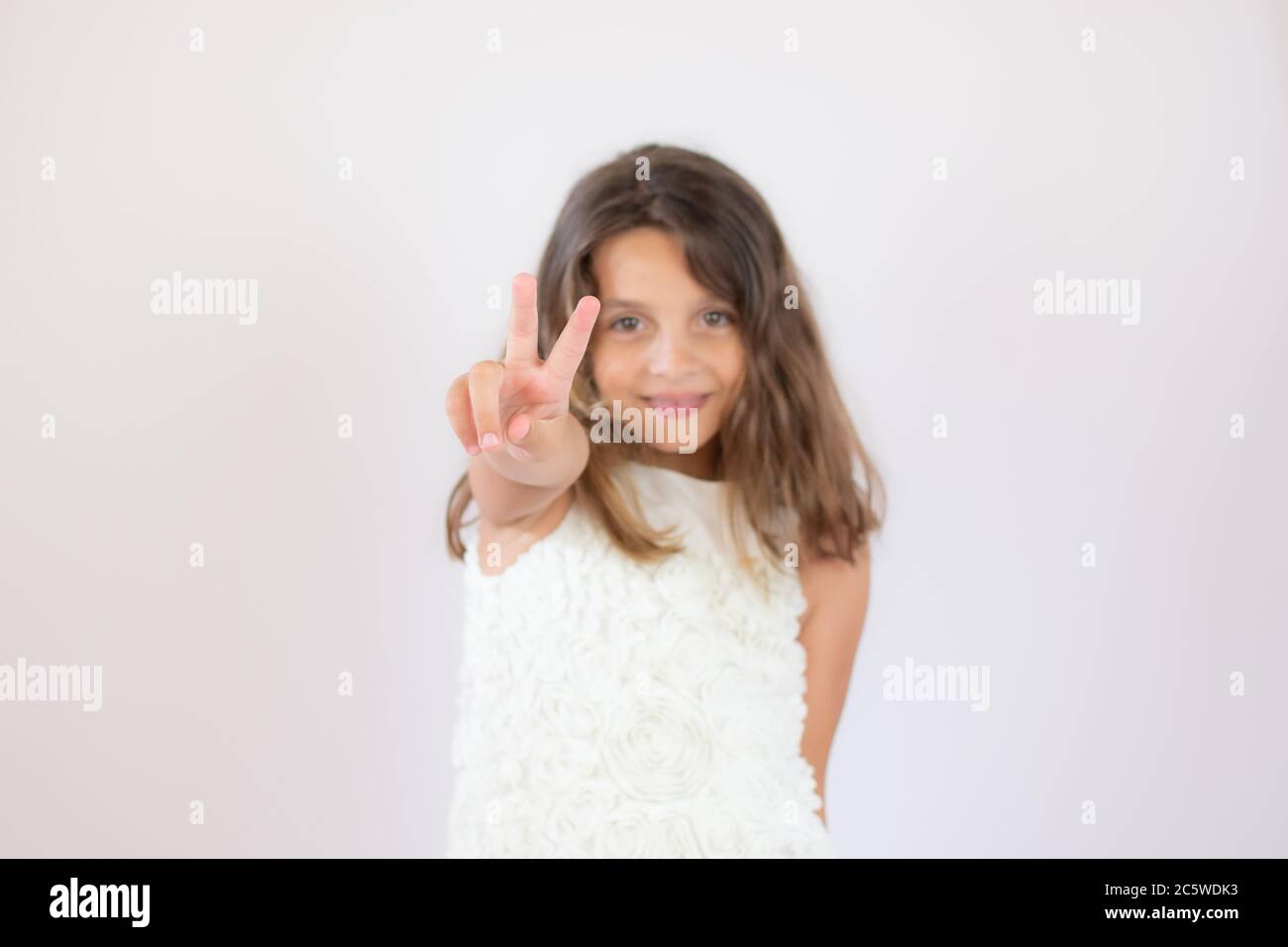 Beautiful little girl making victory gesture with her fingers Stock ...