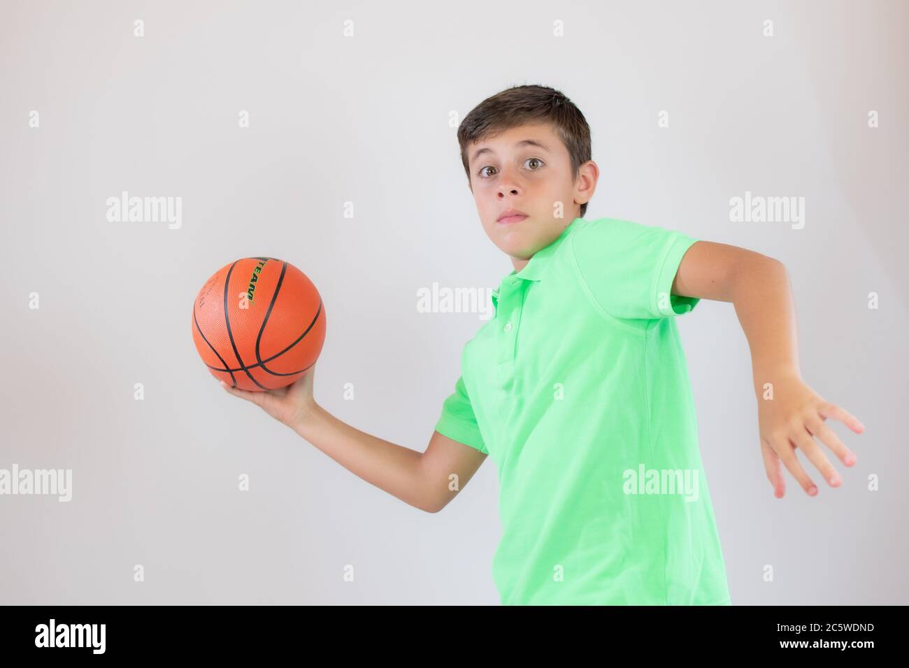 Little boy with green polo playing with a ball Stock Photo - Alamy