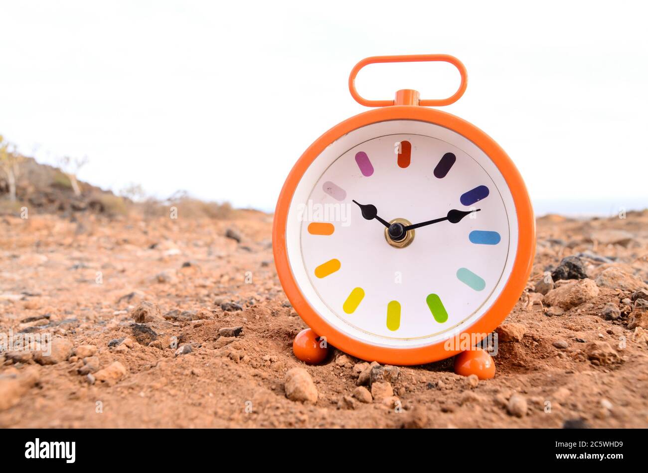 Classic Analog Clock In The Sand On The Rock Desert Stock Photo - Alamy