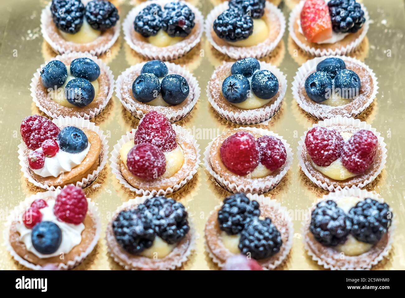 Different sort of small sweet cakes with vanilla, chocolate, berries ...