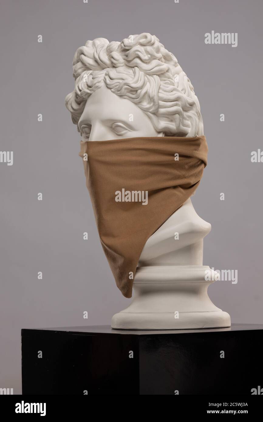 White plaster statue of a bust of Apollo Belvedere in a headscarf ...