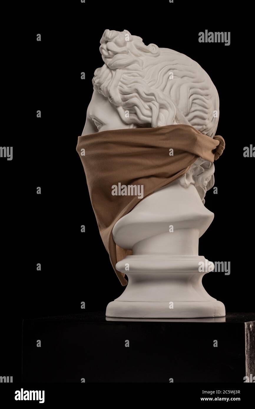 White plaster statue of a bust of Apollo Belvedere in a headscarf ...