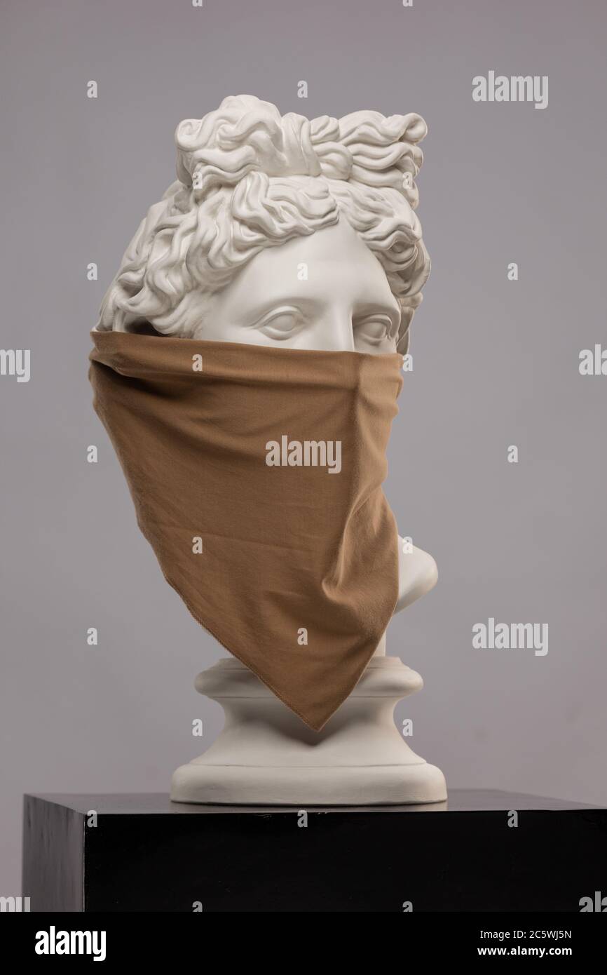 White plaster statue of a bust of Apollo Belvedere in a headscarf ...