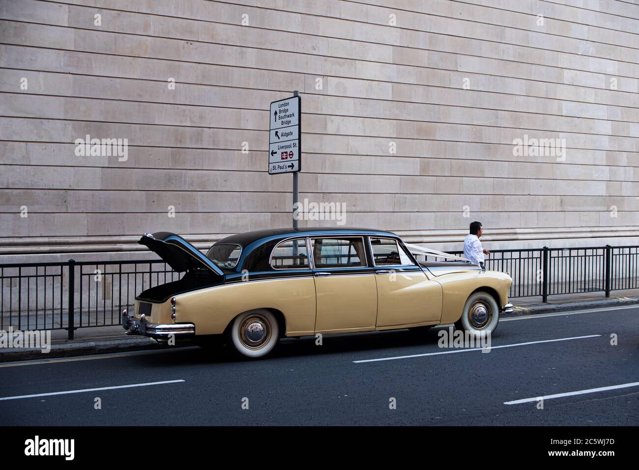 Old stylish retro car with open trunk and driver in front of the car ...