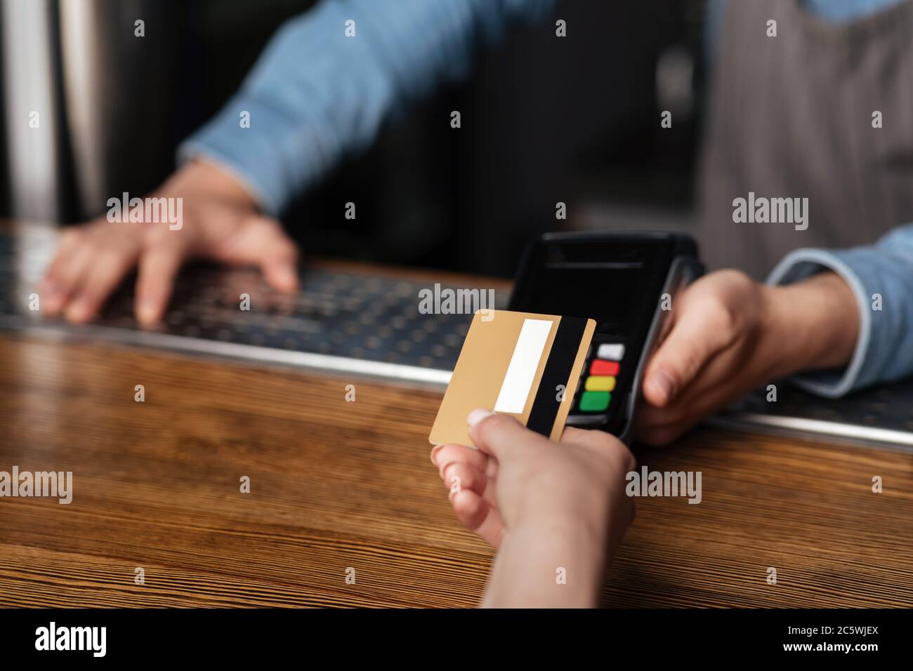 Fast payment for drinks. Girl uses credit card, barman holds terminal ...