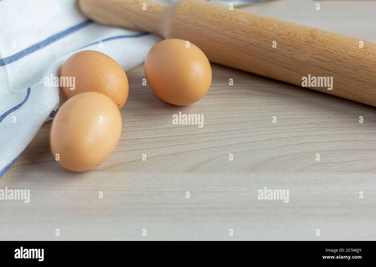 Homemade chicken eggs and a rolling pin on the table.Preparation for ...