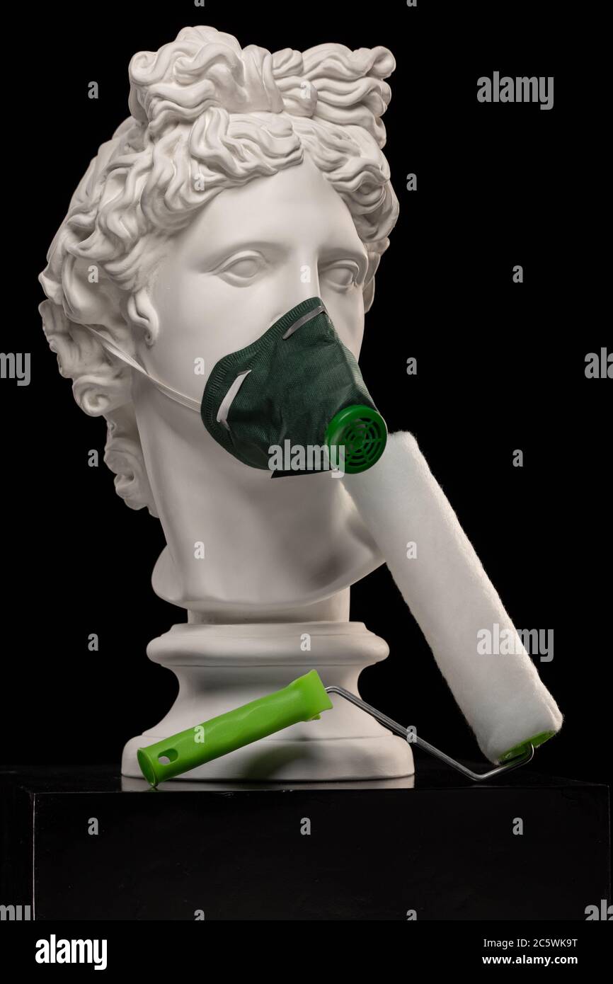 White plaster statue of a bust of Apollo Belvedere in a mask respirator ...