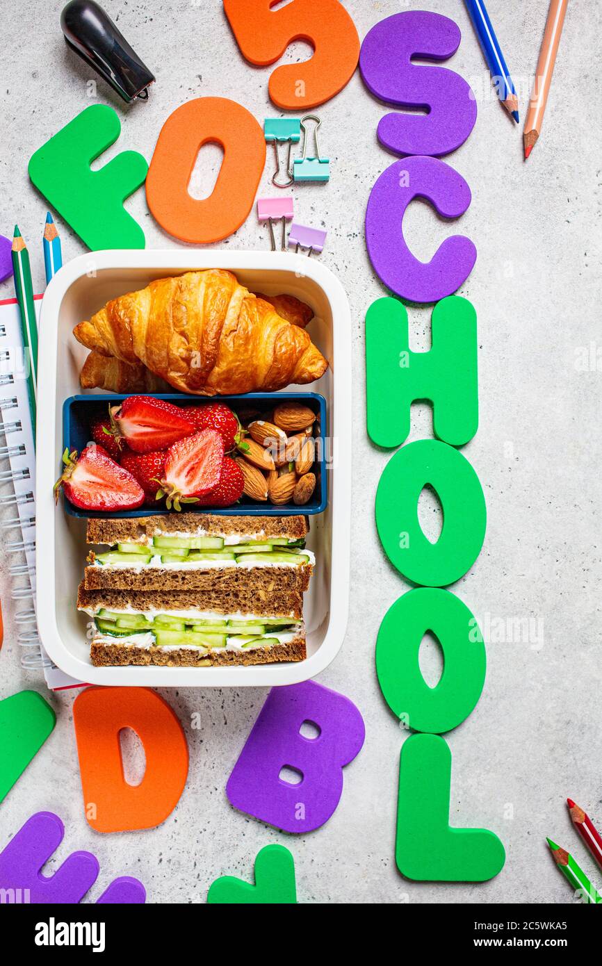 Back to school concept. Lunch box with a sandwich, croissants and ...
