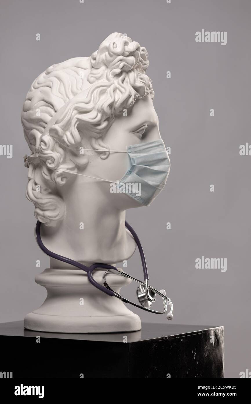 Bust of Apollo Belvedere in a disposable protective mask covering his ...