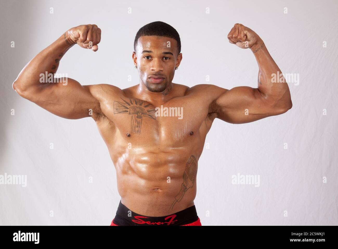 Strong Black man flexing his muscles Stock Photo - Alamy