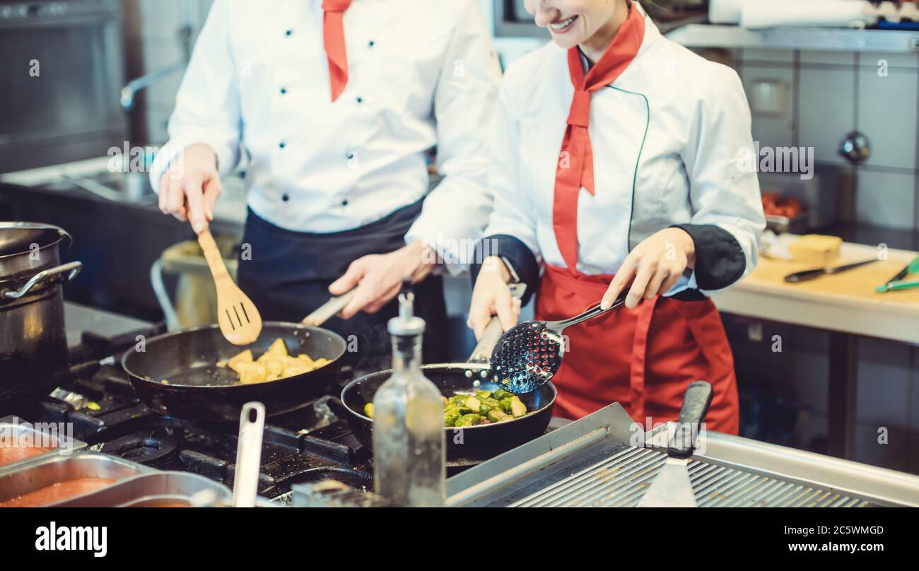 Team of chefs in a kitchen preparing fantastic food in pans Stock Photo ...
