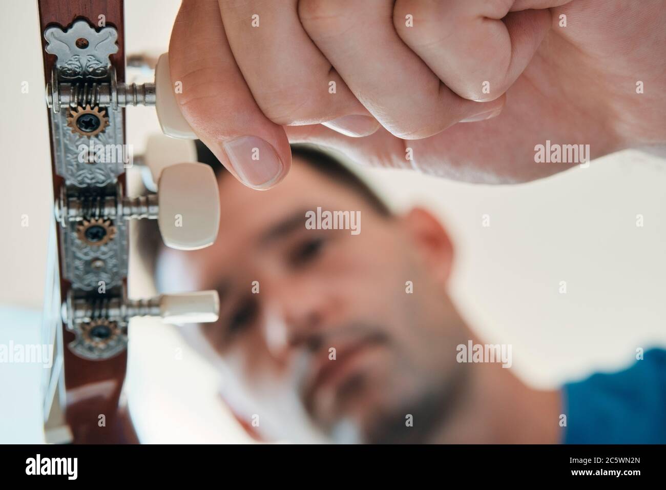 Man Tuning His Acoustic Guitar Before Playing Music Stock Photo - Alamy