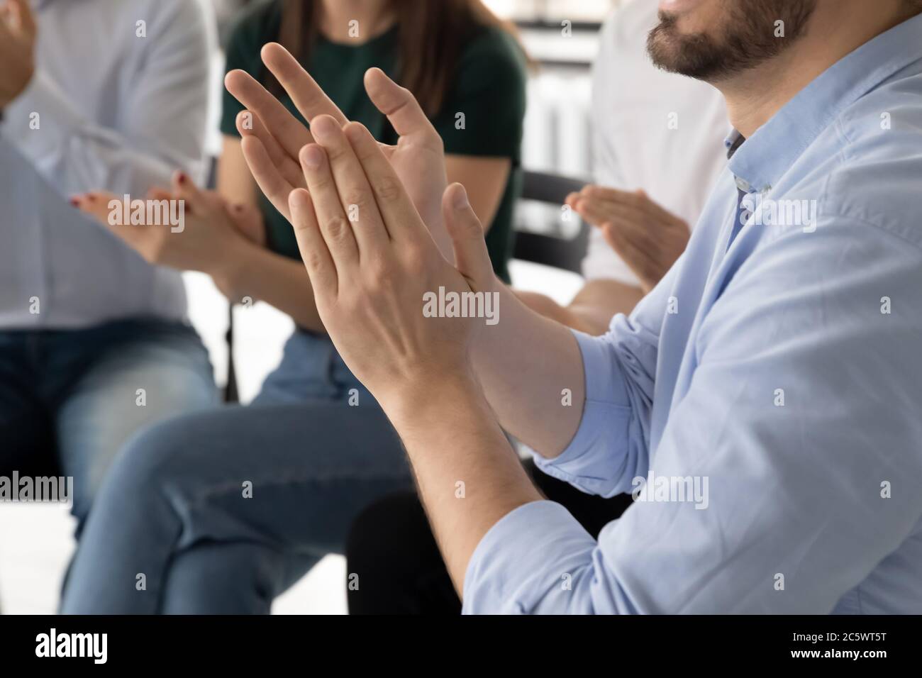 People sit on chairs clapping hands close up image Stock Photo - Alamy