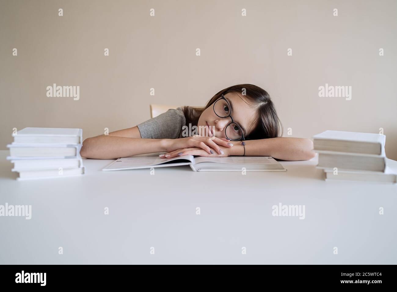 Cute teenage girl tired of studying and doing her homework. Tired and ...