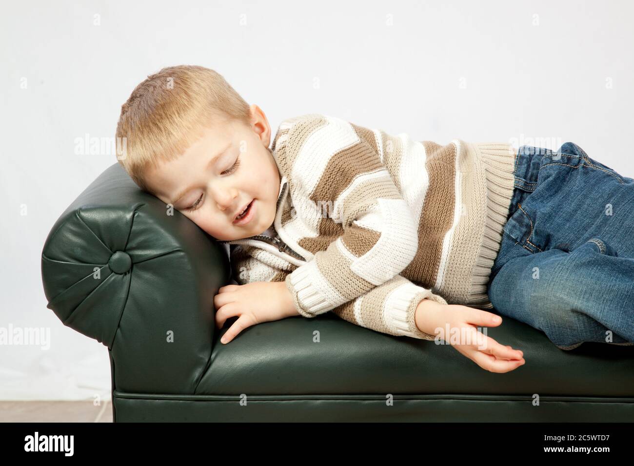 Young Blond boy laying down on a bench Stock Photo - Alamy