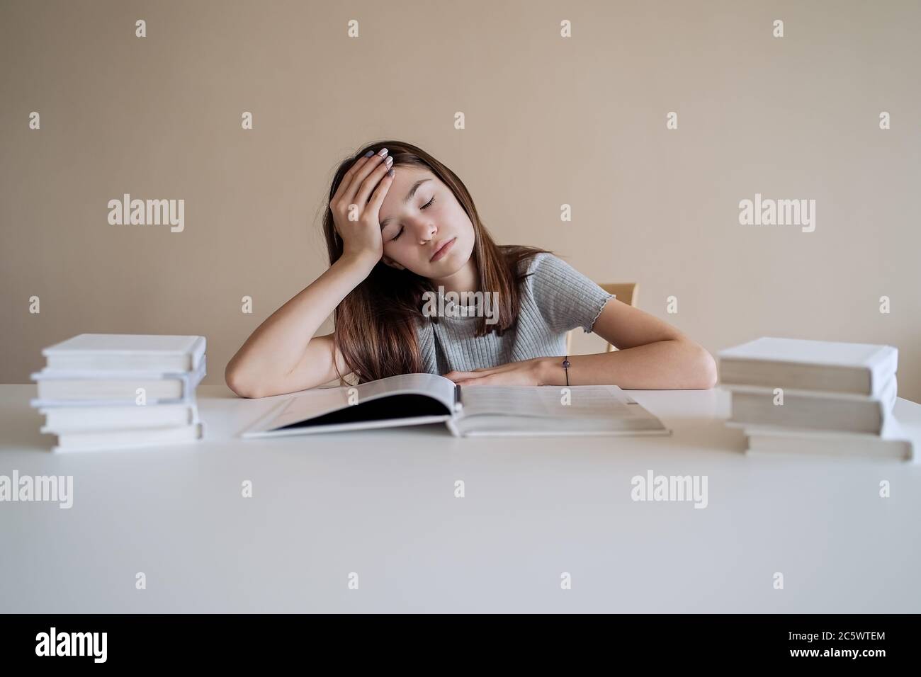 Cute teenage girl tired of studying and doing her homework. Tired and ...