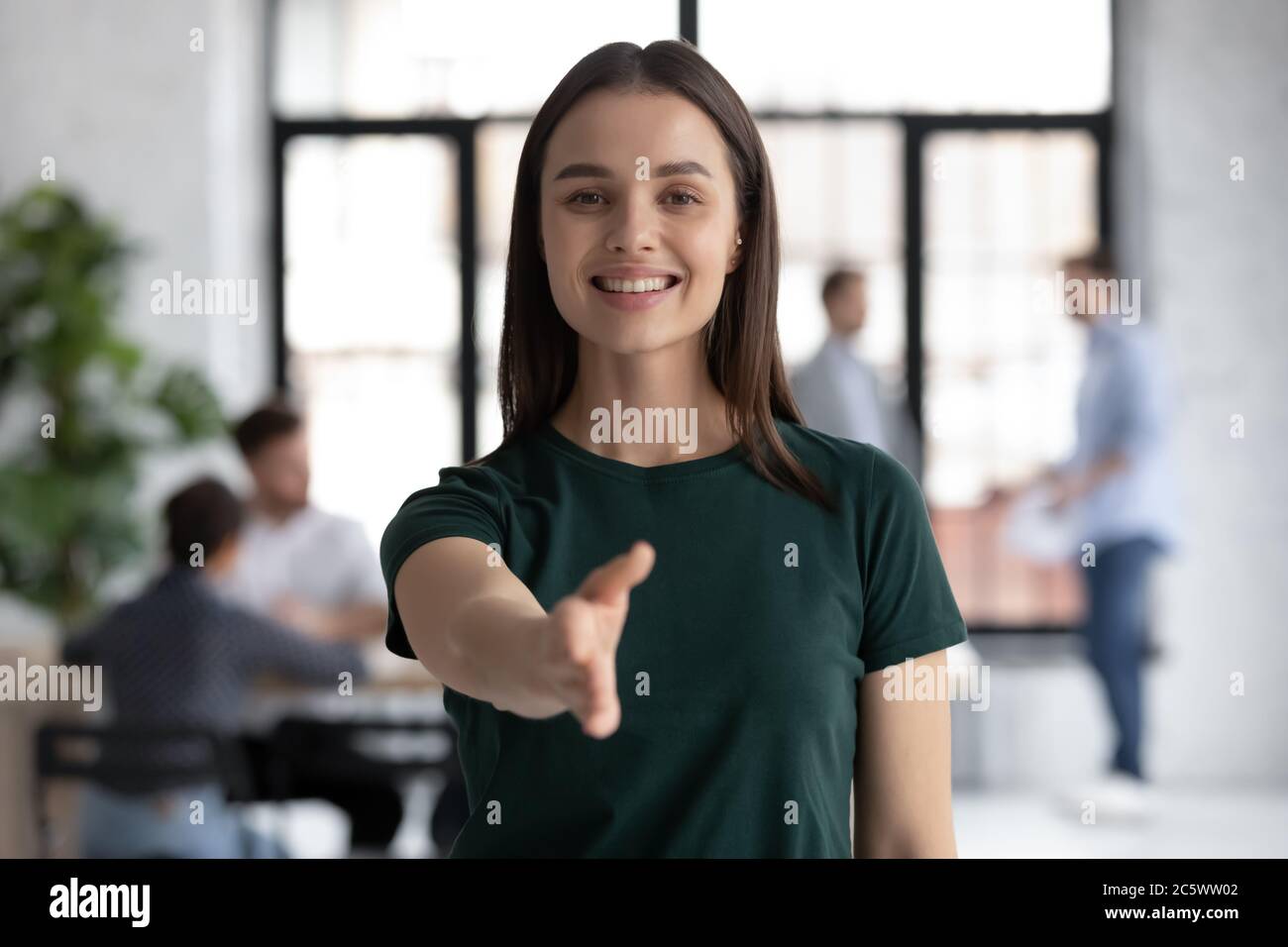 Female manager welcoming client stretching hand for handshake Stock ...