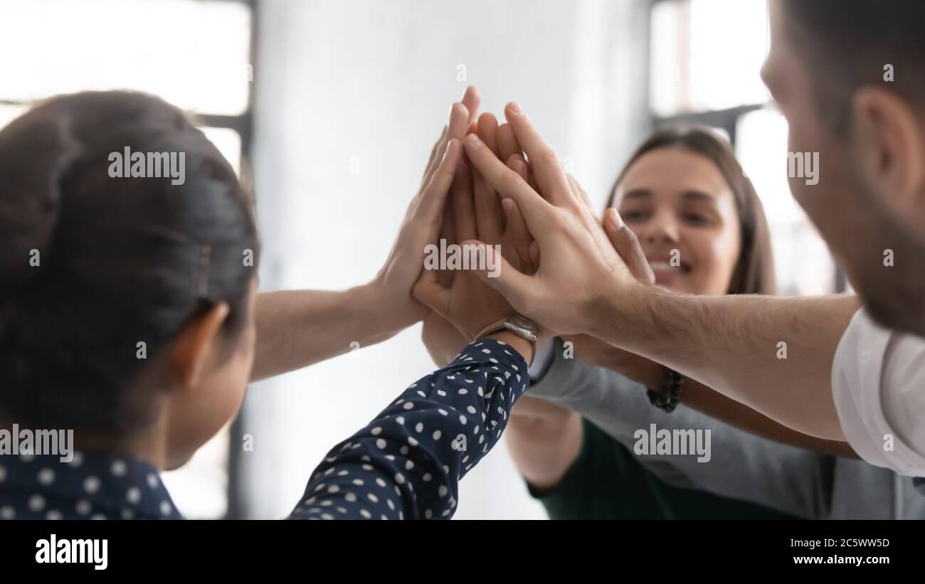 Excited staff members giving high five sharing success closeup image ...