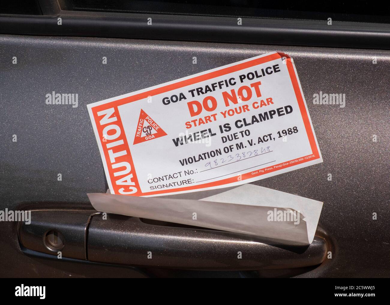 Ticket sticker and penalty notice on door handle of illegally parked ...