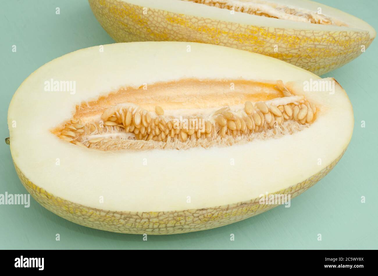 Cut half melon on a green background. Summer desserts Stock Photo - Alamy