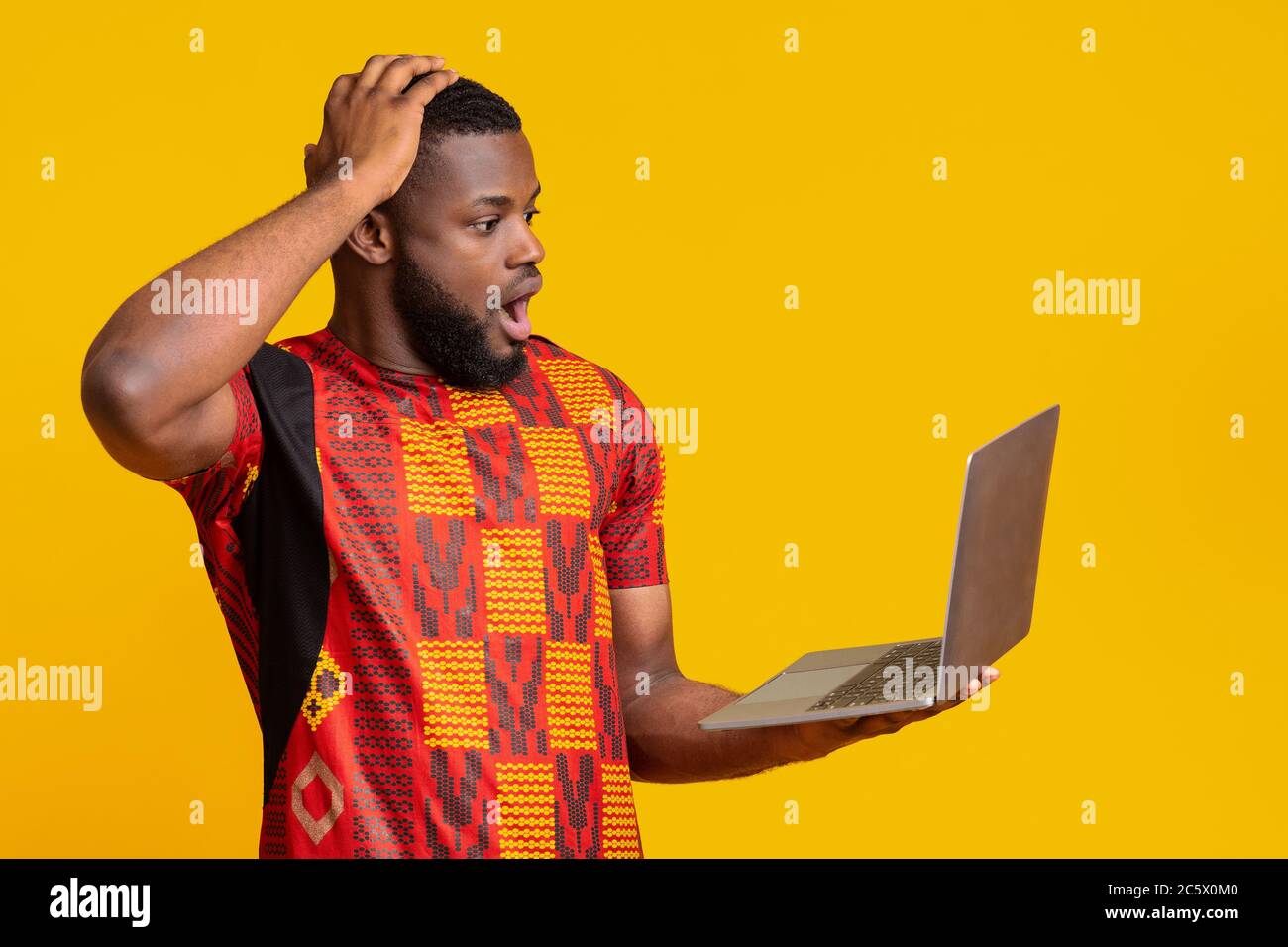 Shocked black guy looking at laptop screen Stock Photo - Alamy