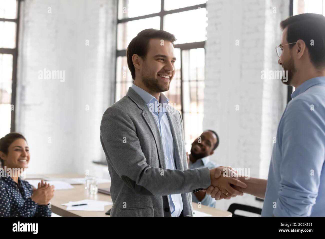Two businessmen shake hands express respect accomplish negotiation ...