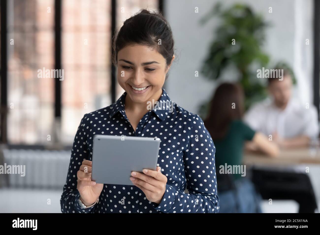 Indian businesswoman look at tablet device screen preparing ...