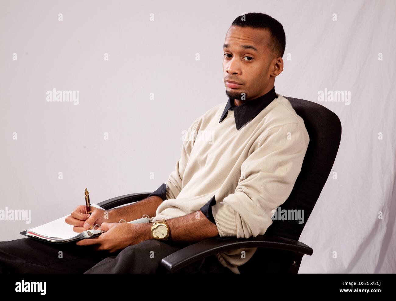 Handsome black man sitting and writing Stock Photo - Alamy