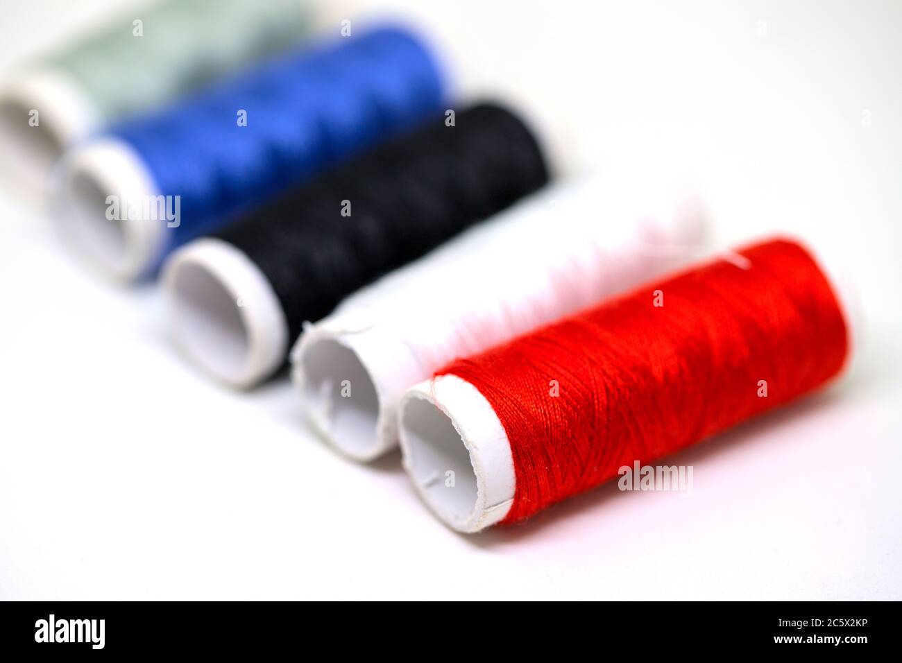 Thread spool set on white background. Basic color of threads: red ...
