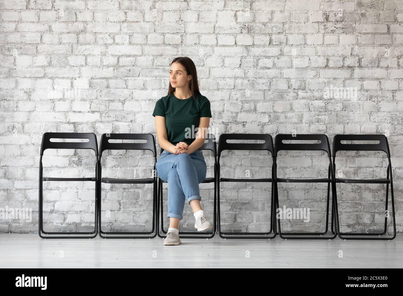 Woman sit on chair looking away wait for job interview Stock Photo - Alamy