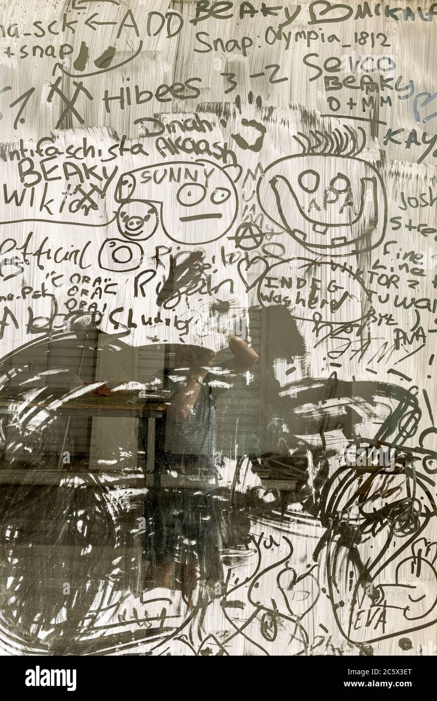 Drawings and writings on window whitewash paint creates an abstract ...