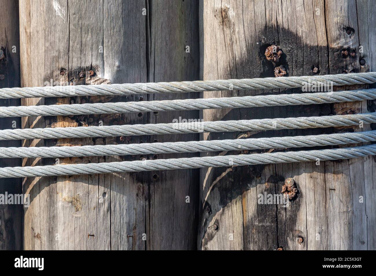 Rope tied around a wooden post at a harbor Stock Photo - Alamy