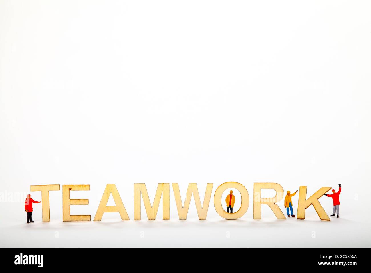 Wooden teamwork sign with miniature figure workmen working together to ...