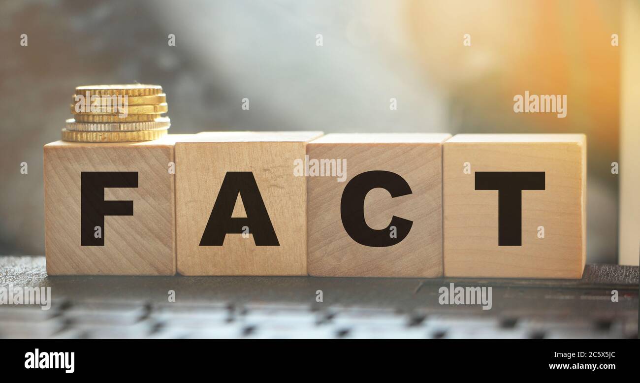 FACT Word Written In Wooden Cubes on computer keyboard and coins Stock ...