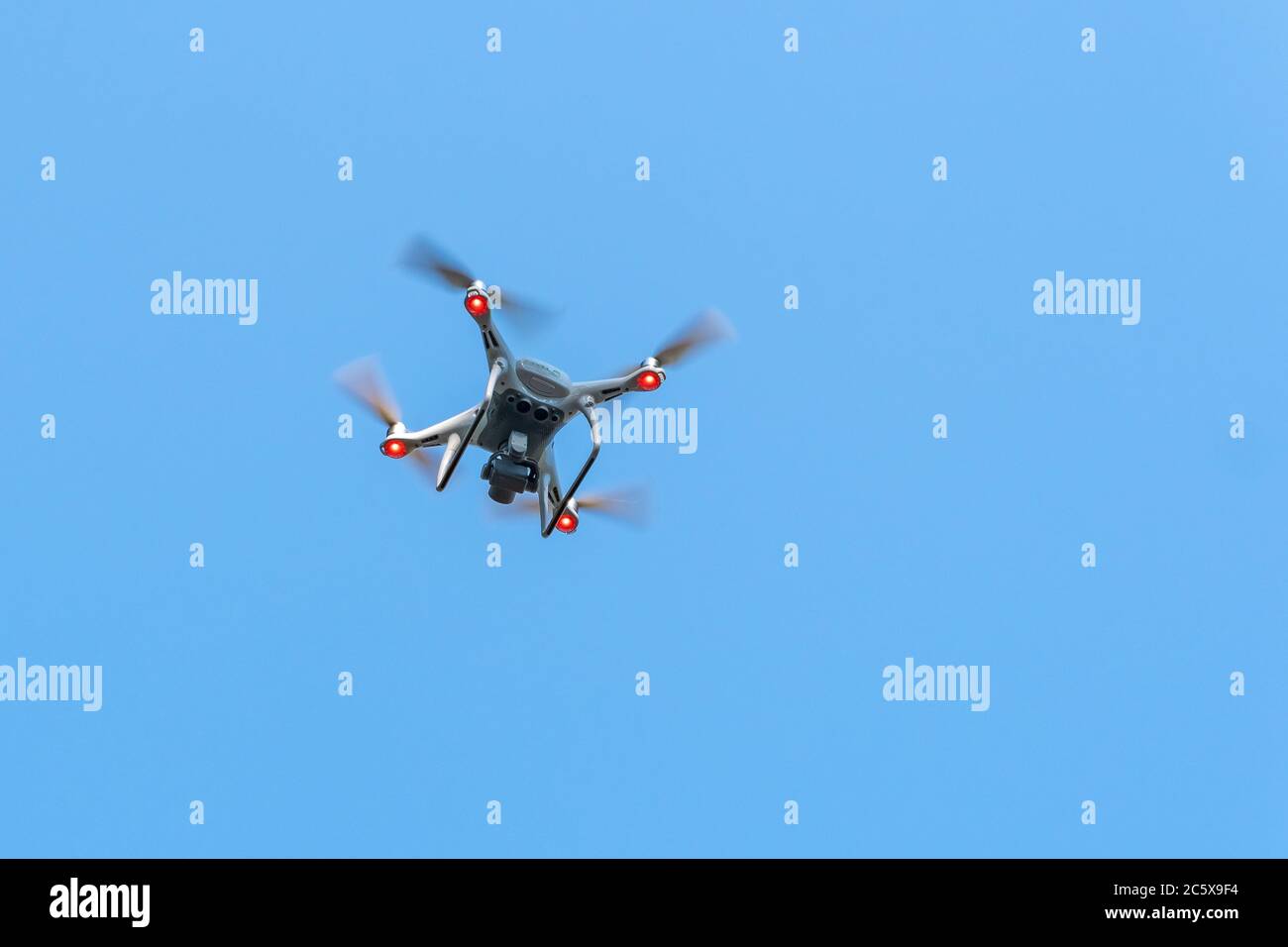 Flying drone with blue sky background Stock Photo - Alamy