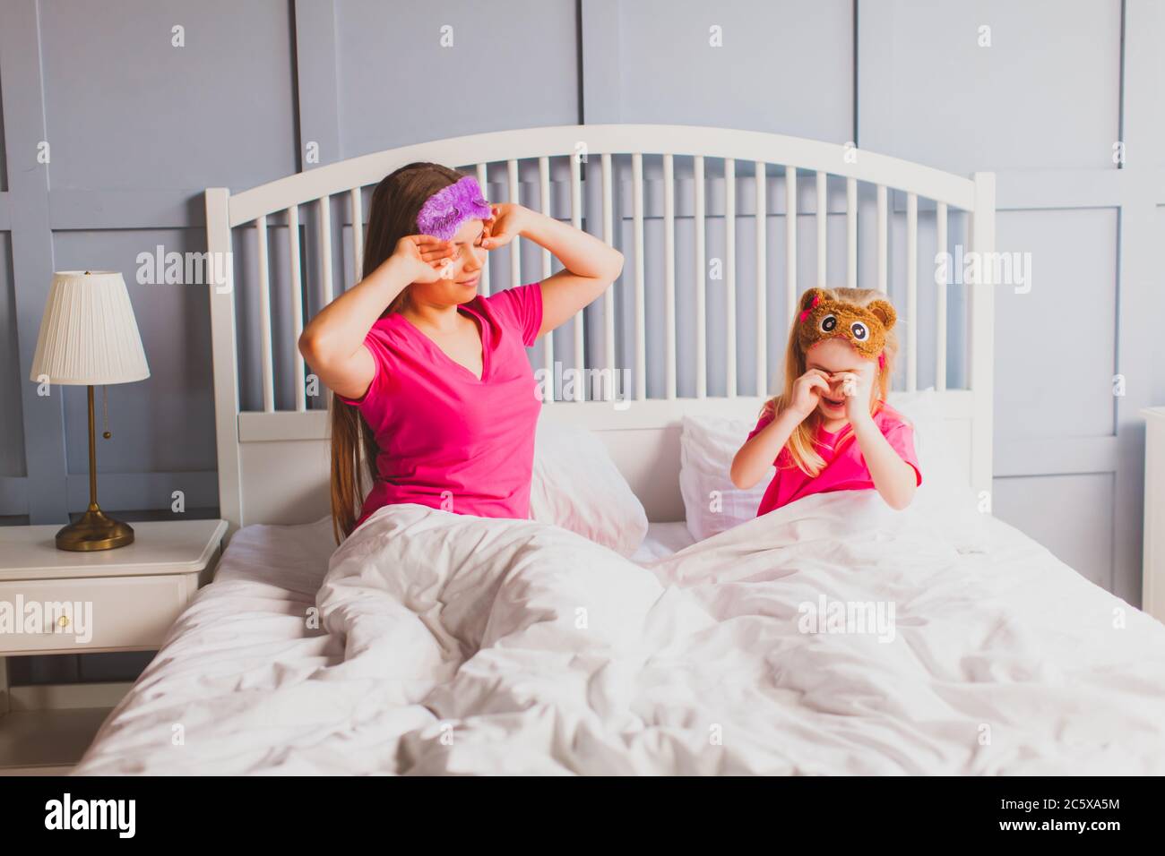 Joyful awakening of mom and daughter after a healthy sleep Stock Photo ...