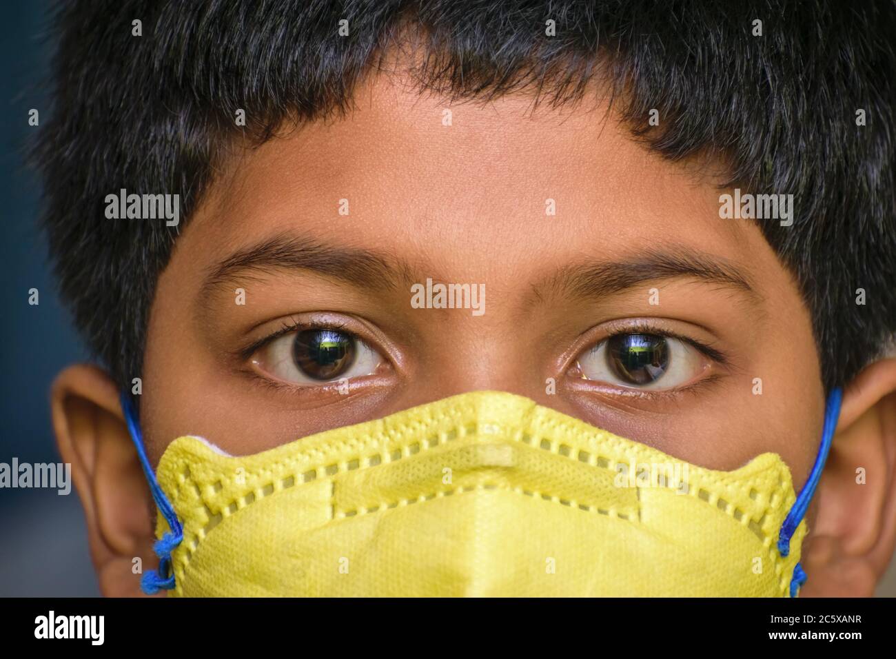 Isolated young Indian boy with prominent eyes wearing N95 face mask for ...