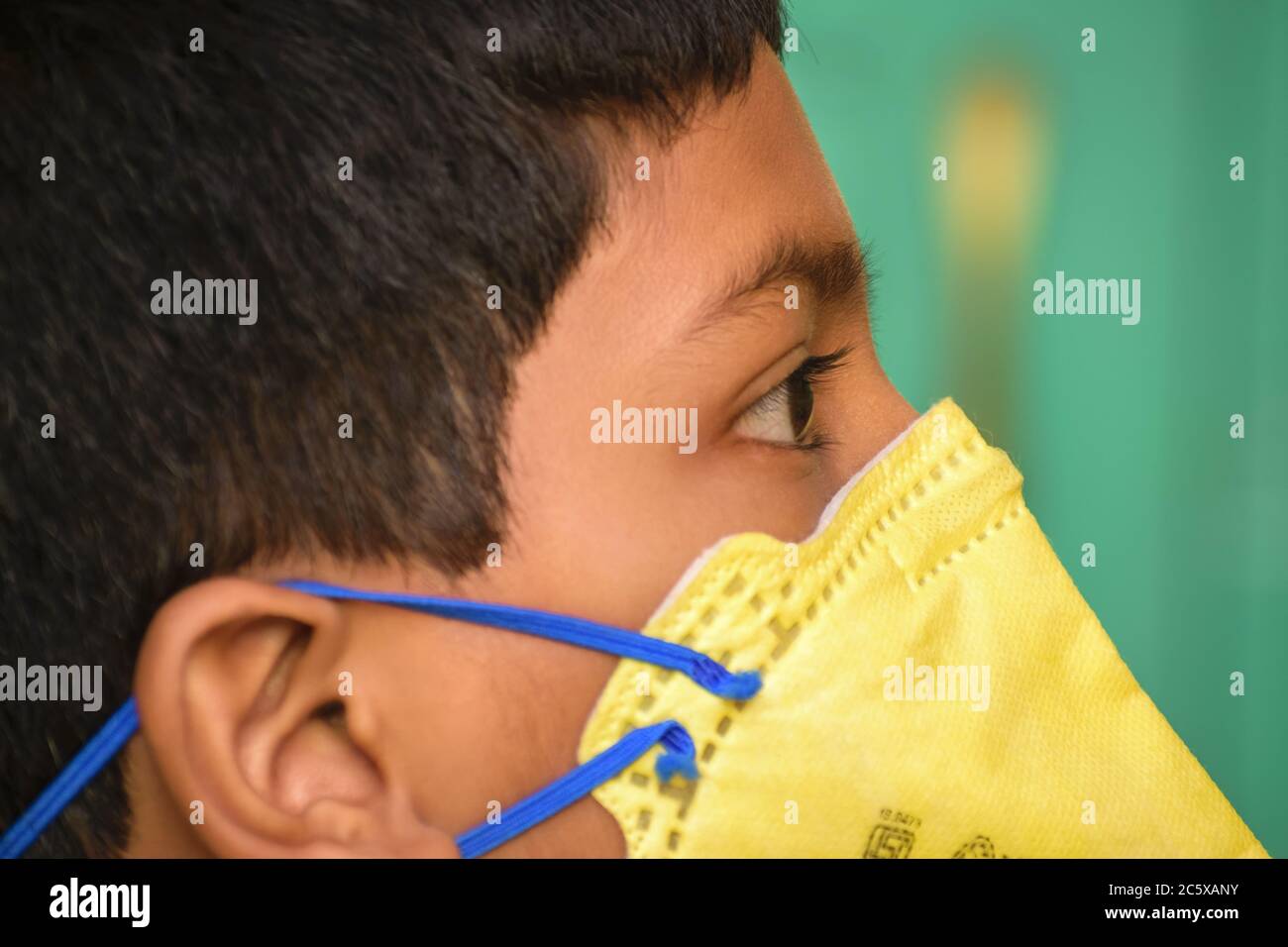 Isolated young Indian boy with prominent eyes wearing N95 face mask for ...